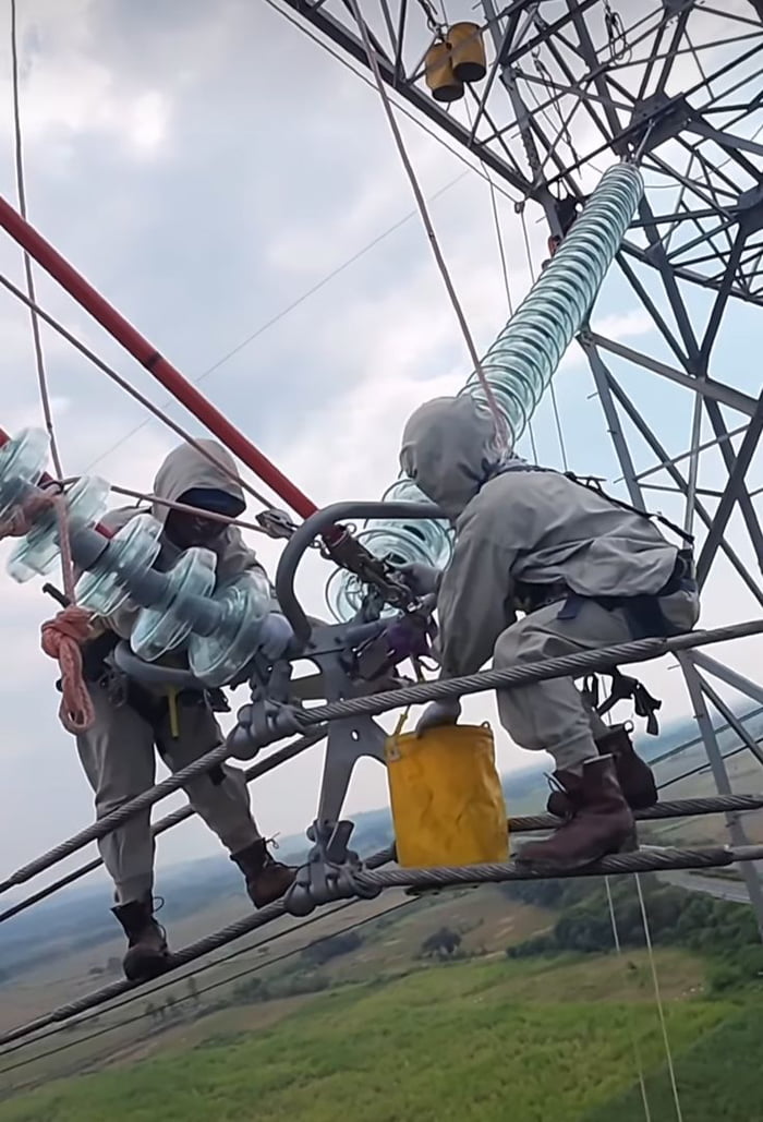 Work on active high voltage powerlines in Faraday Suits. - 9GAG