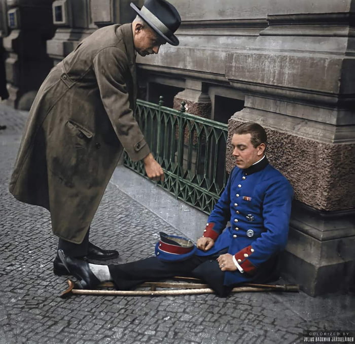 German civilian offering money to a disabled First World War veteran ...