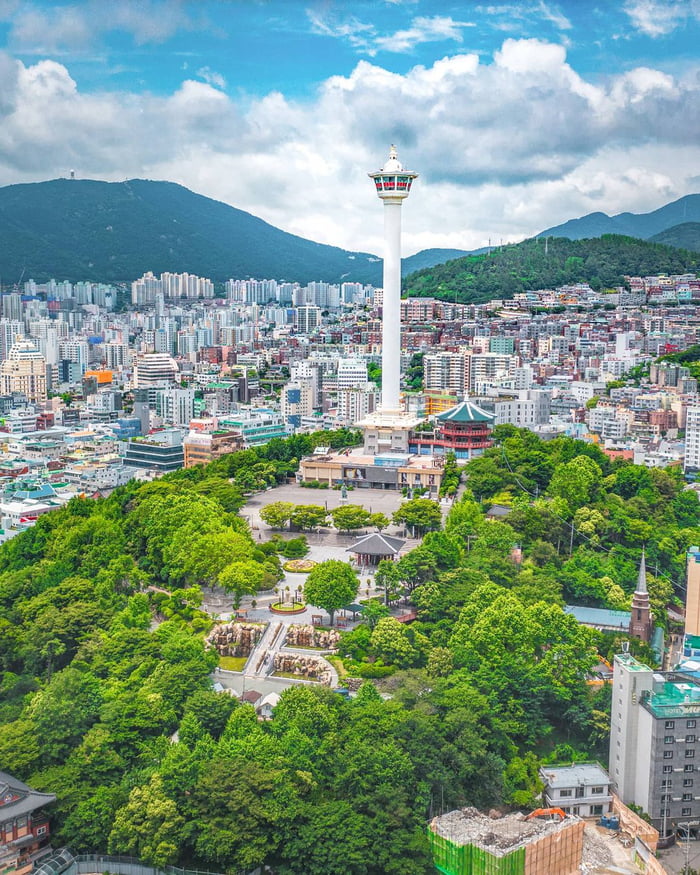 Busan Tower on a hill park surrounded by the dense cityscape of Busan ...