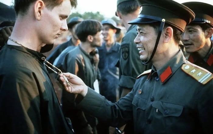 Vietnamese soldier laughing at the peace sign necklace of the captured ...